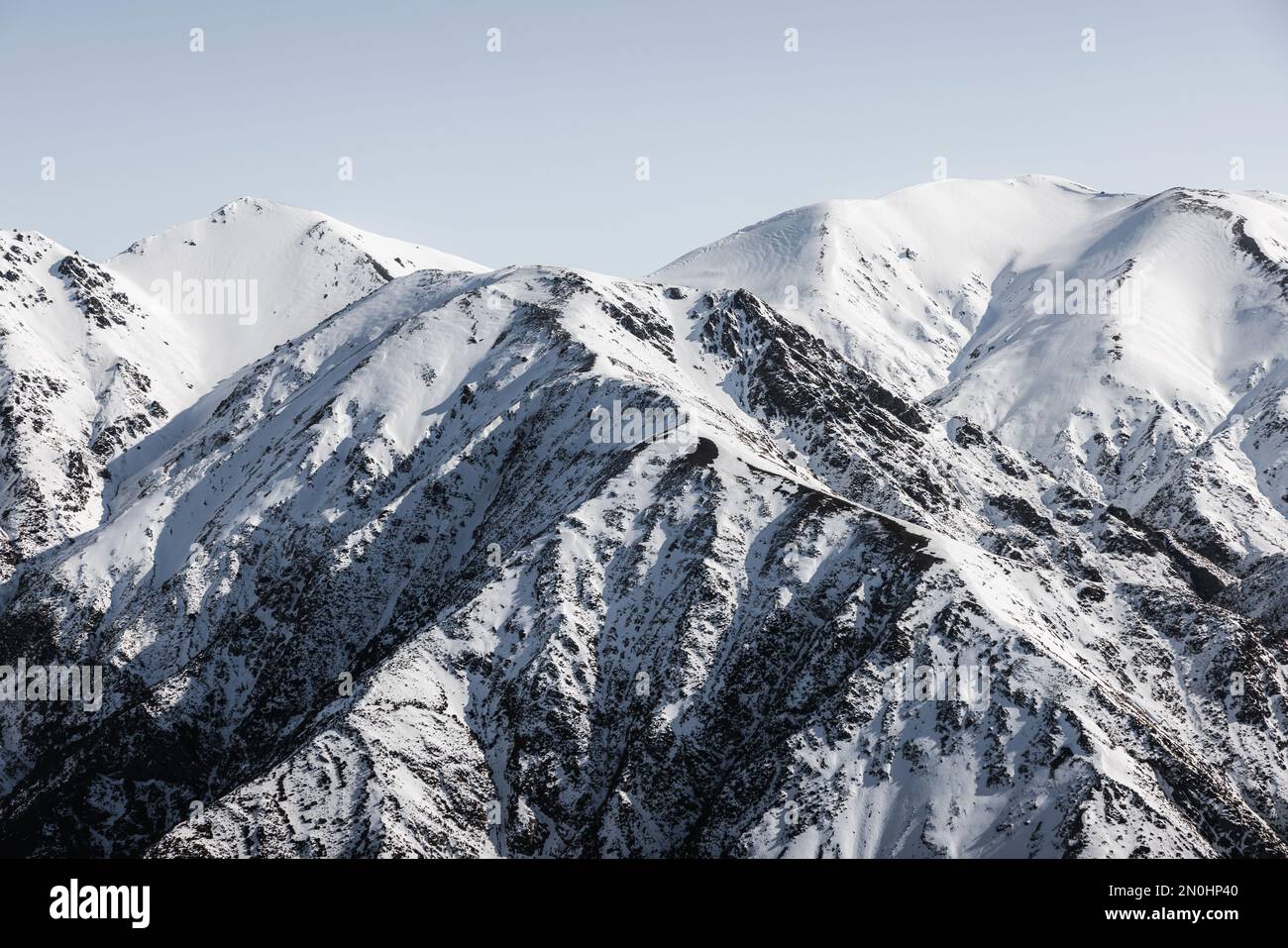 Snow covered mountain peaks set against clear skies, providing ...