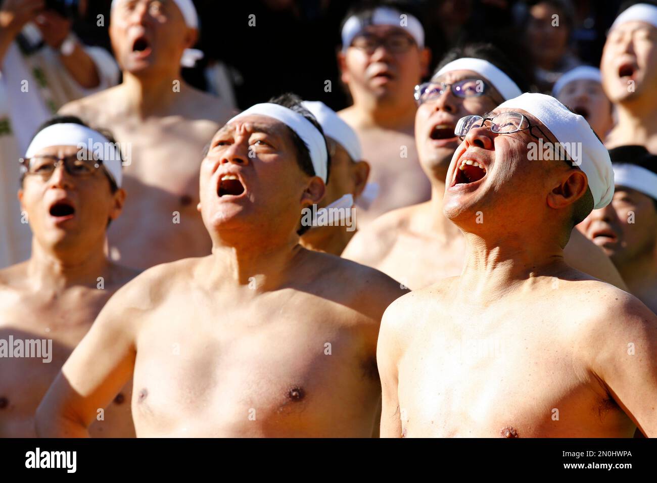 Japanese bathers exercise before dipping in a cold water tub with ...