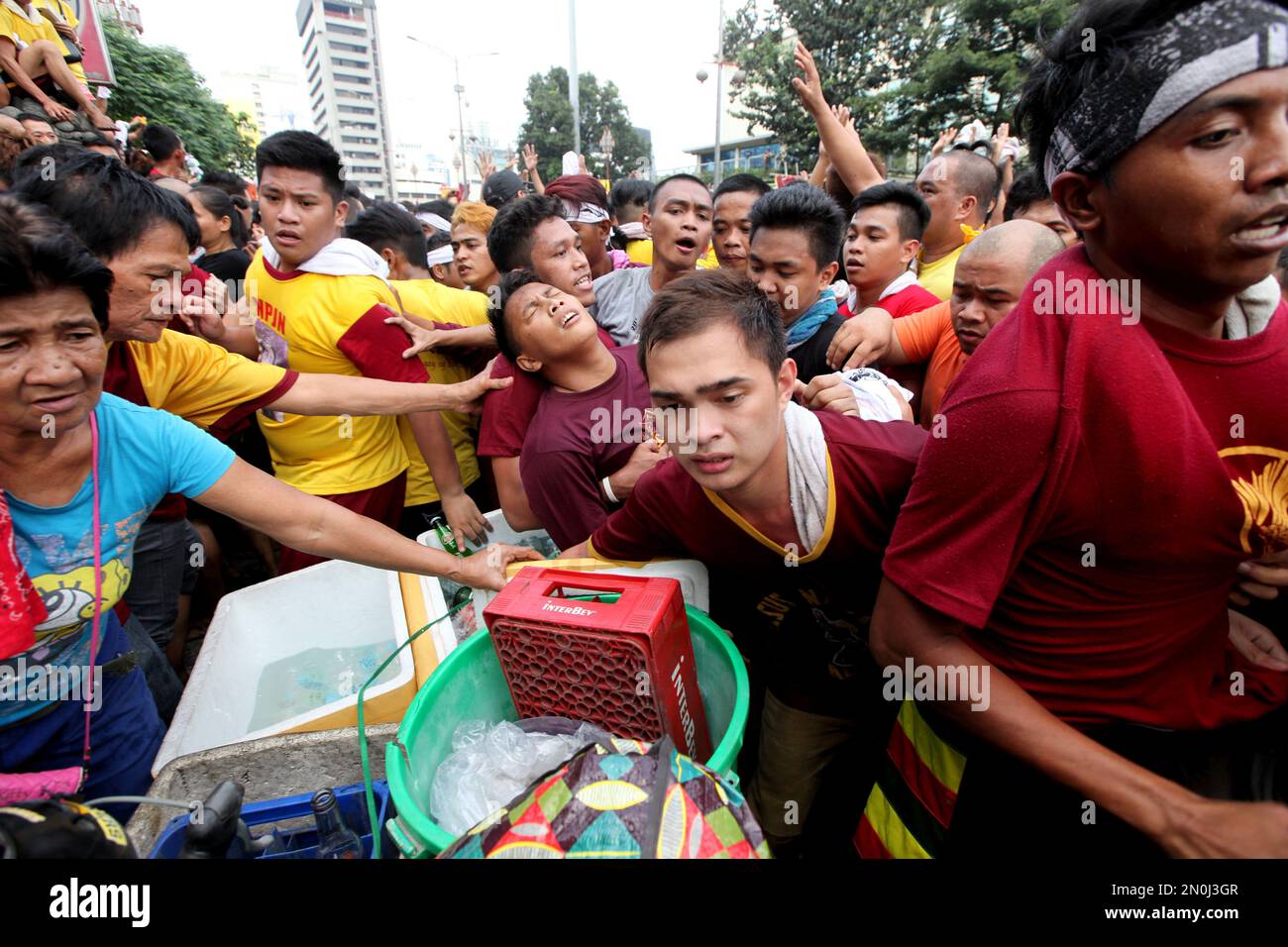 A devotee, center, grimaces as tens of thousands of Catholic devotees ...