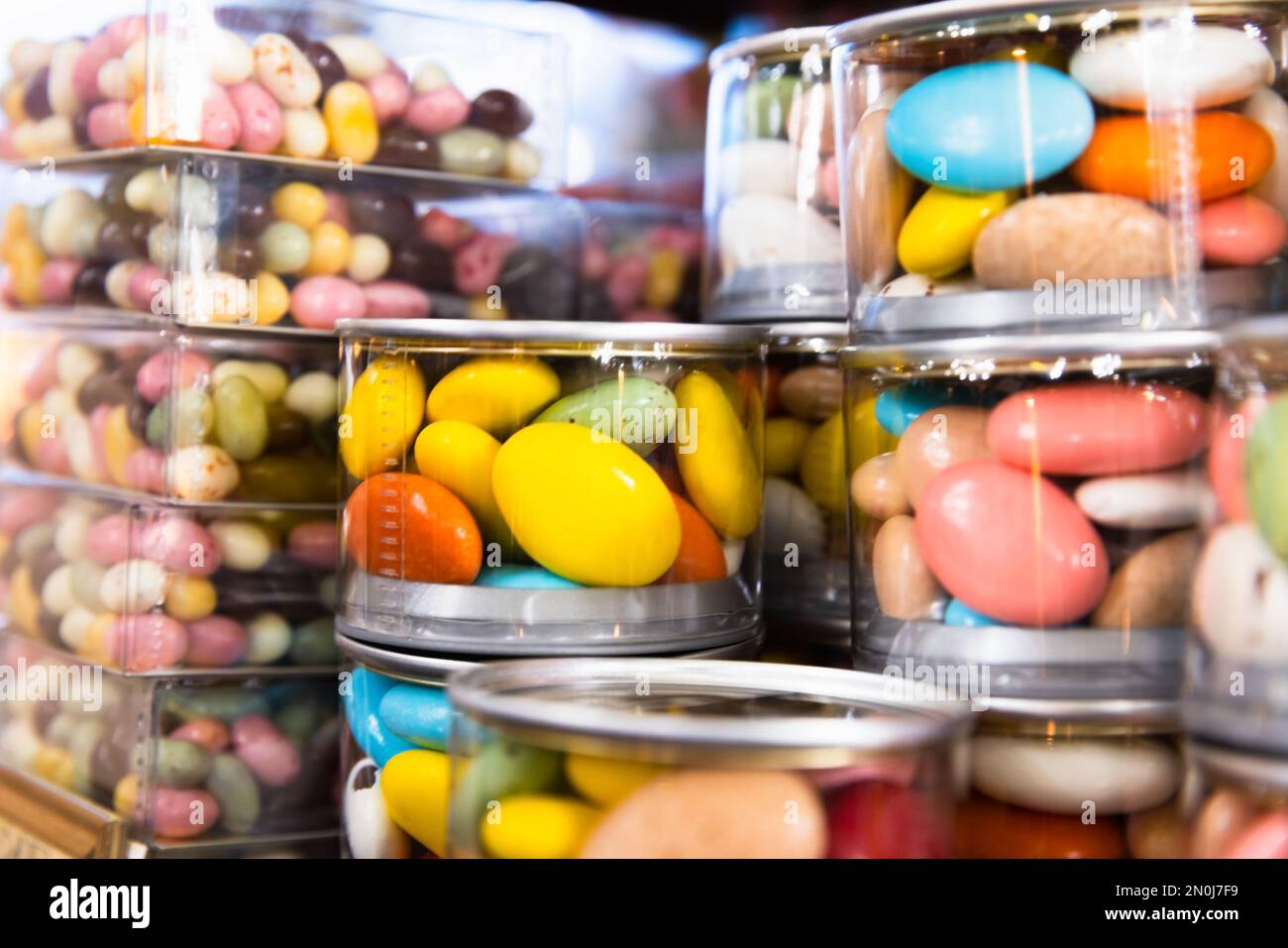 Candies dragee are in transparent plastic jars on a checkout counter in ...