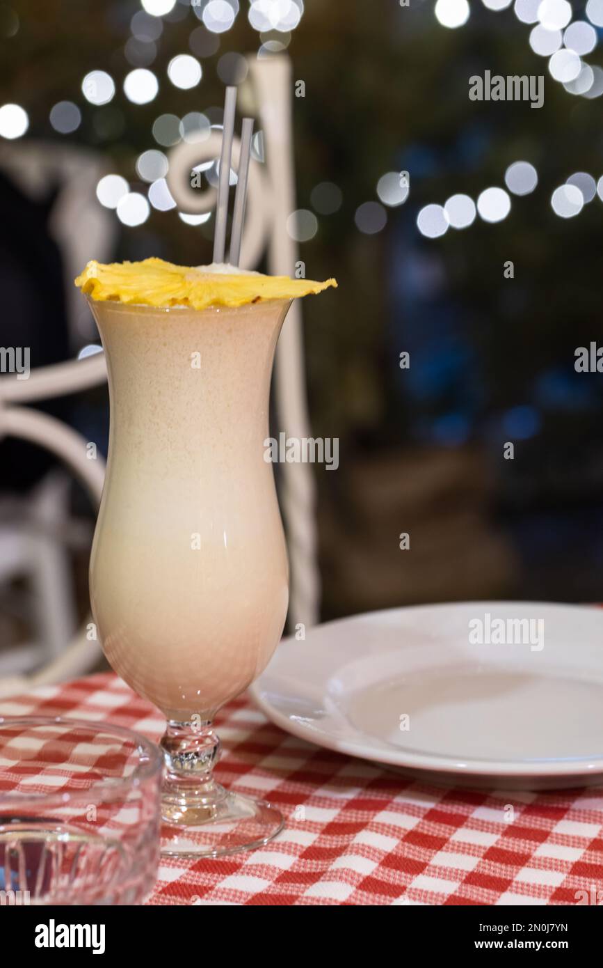 Glass of a milkshake is on a table in an Italian restaurant, close up ...