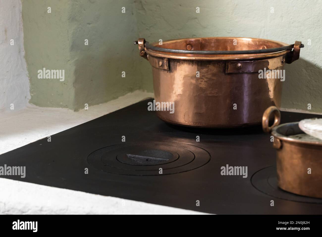 Vintage copper pans stand on a Russian stove Stock Photo - Alamy