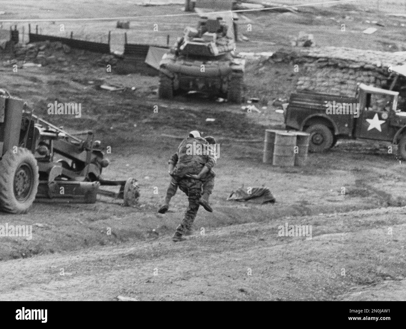 A U.S. Special Forces soldier carries a wounded Vietnamese trooper to ...