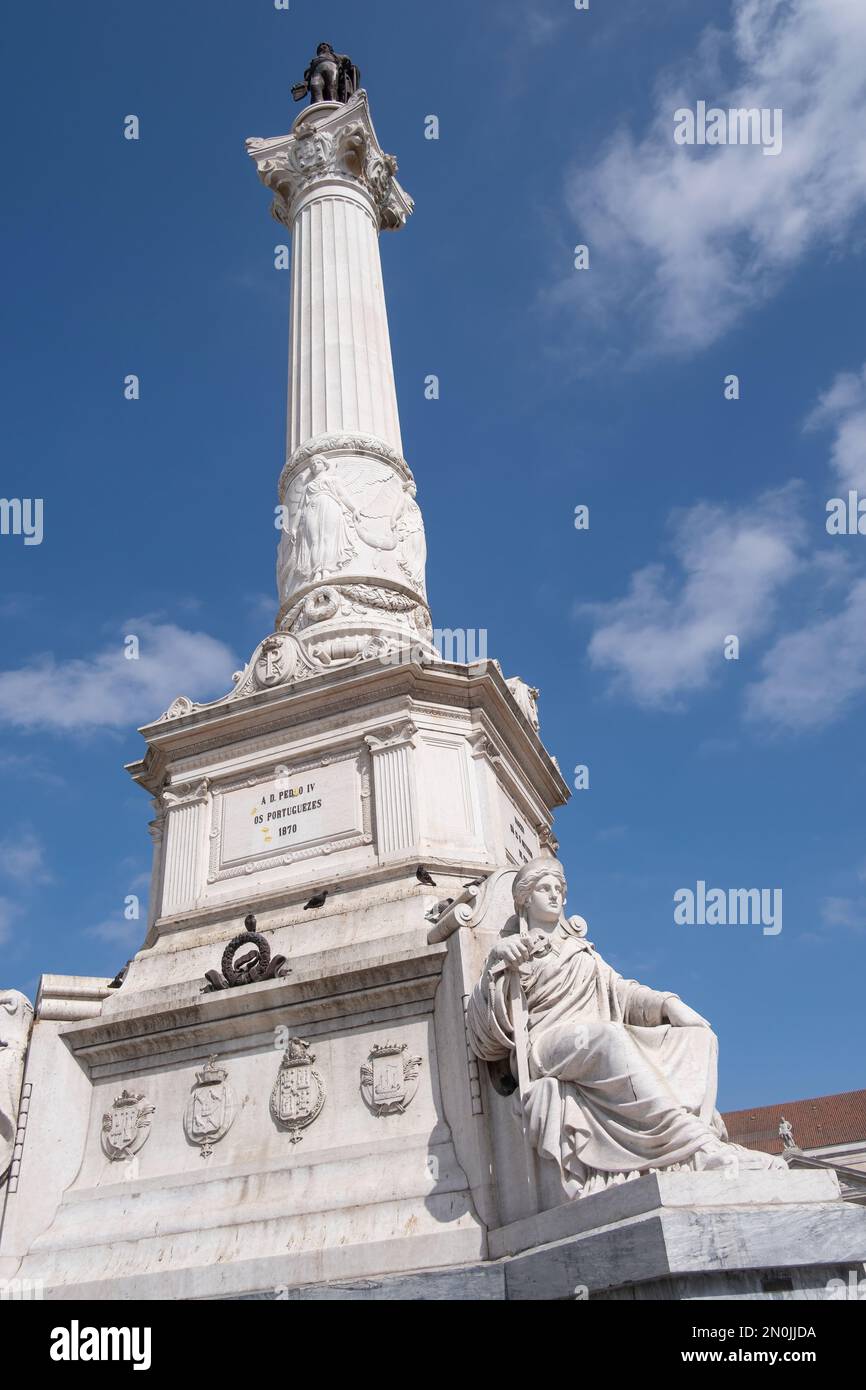 A huge white stone column with a bronze statue of a king of Portugal ...