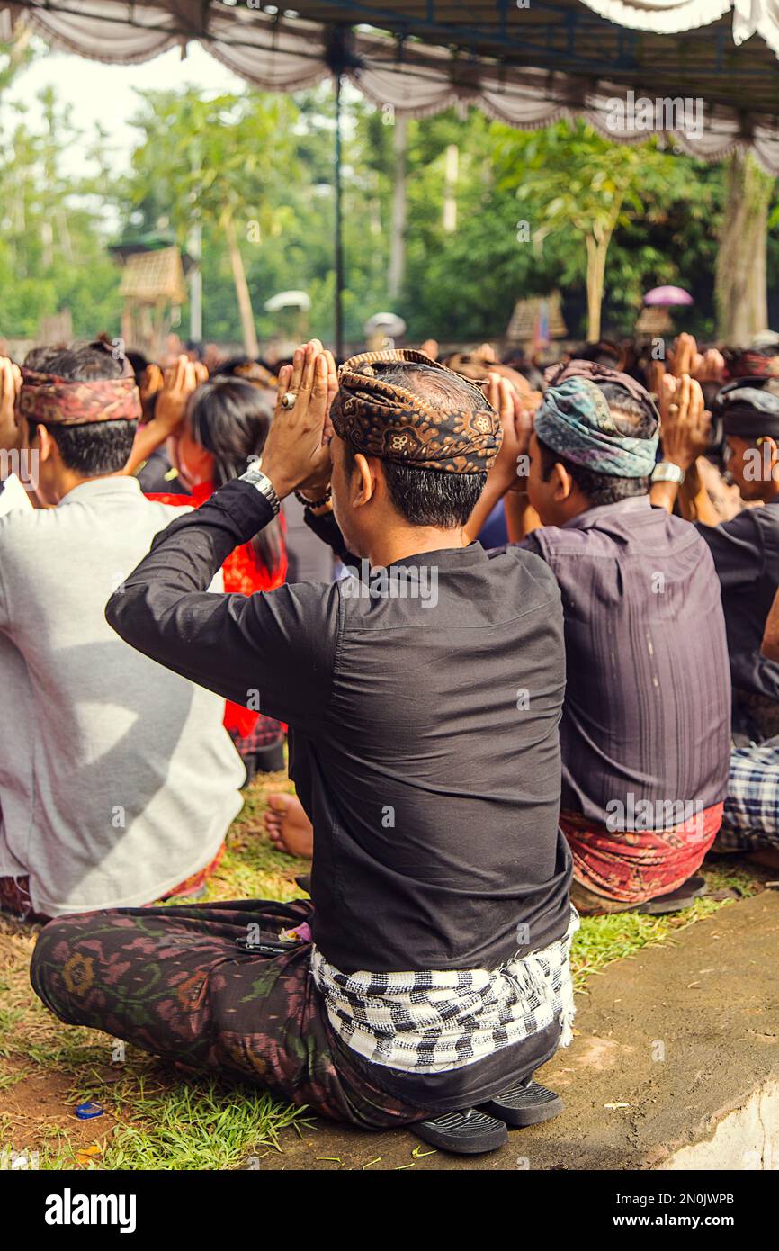 Many people in an Indian temple praying during a religious ceremony ...