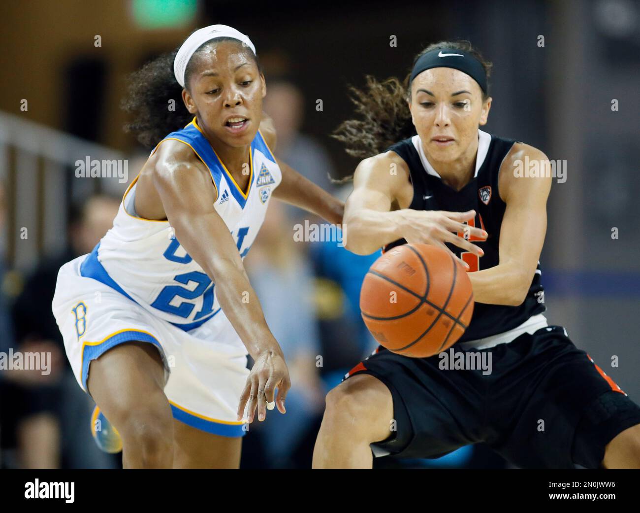 UCLA guard Nirra Fields, left, and Oregon State guard Gabriella Hanson, right, reach for a loose ...