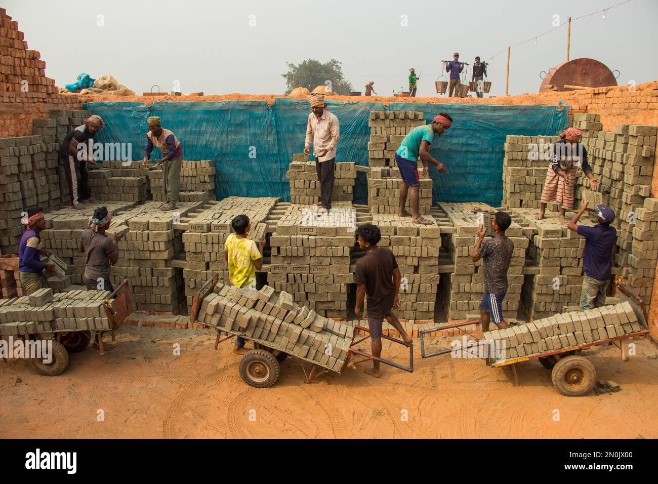 People are working hard in the brick field. This image was taken from ...