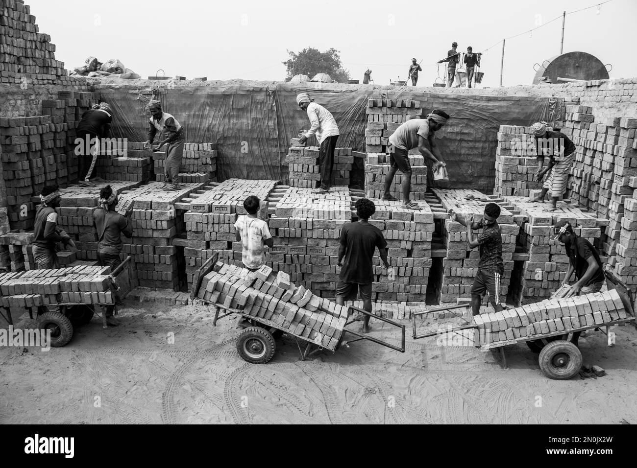 People are working hard in the brick field. This image was taken from ...
