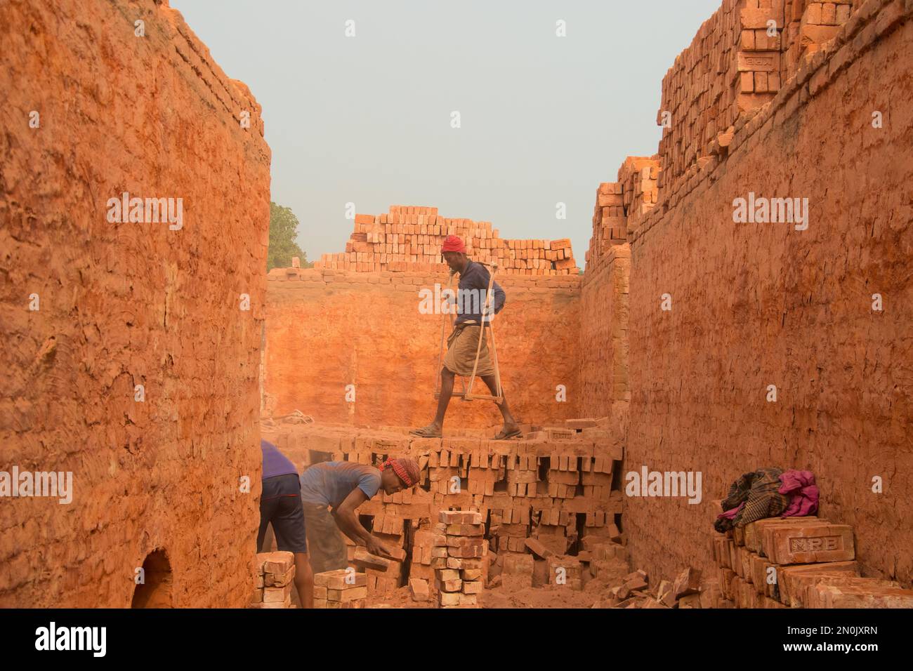People are working hard in the brick field. This image was taken from ...