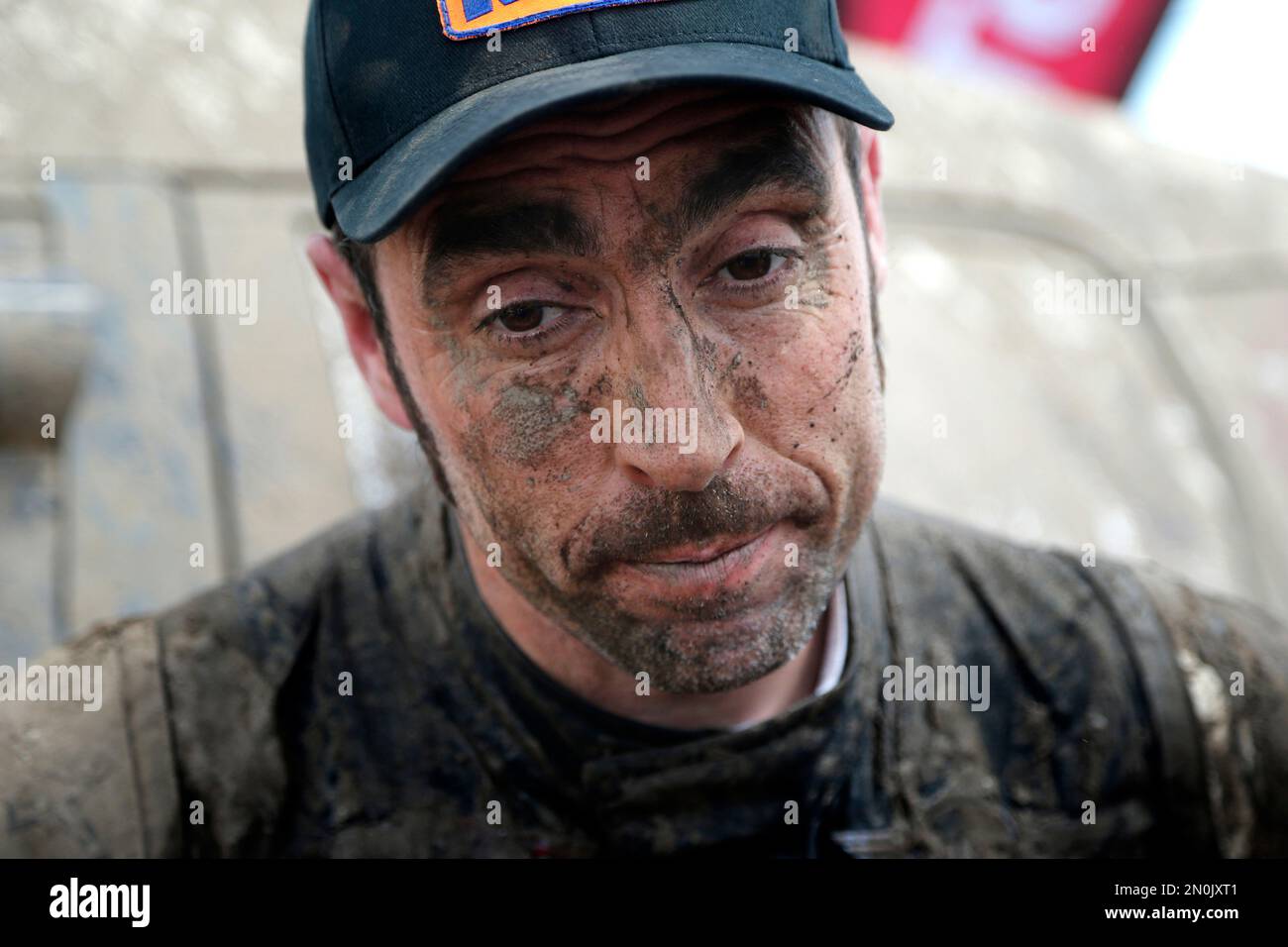 Mini driver Nani Roma, from Spain, is covered in dirt after completing ...