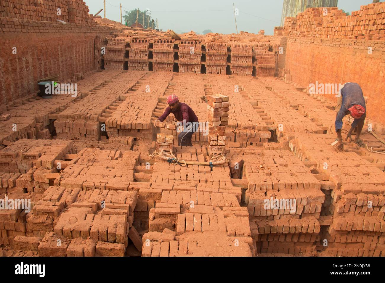 People are working hard in the brick field. This image was taken from ...