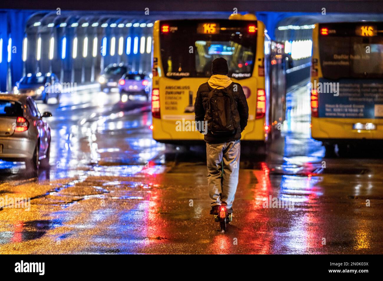 Street at the main station, e-scooter driver rainy weather, city centre ...