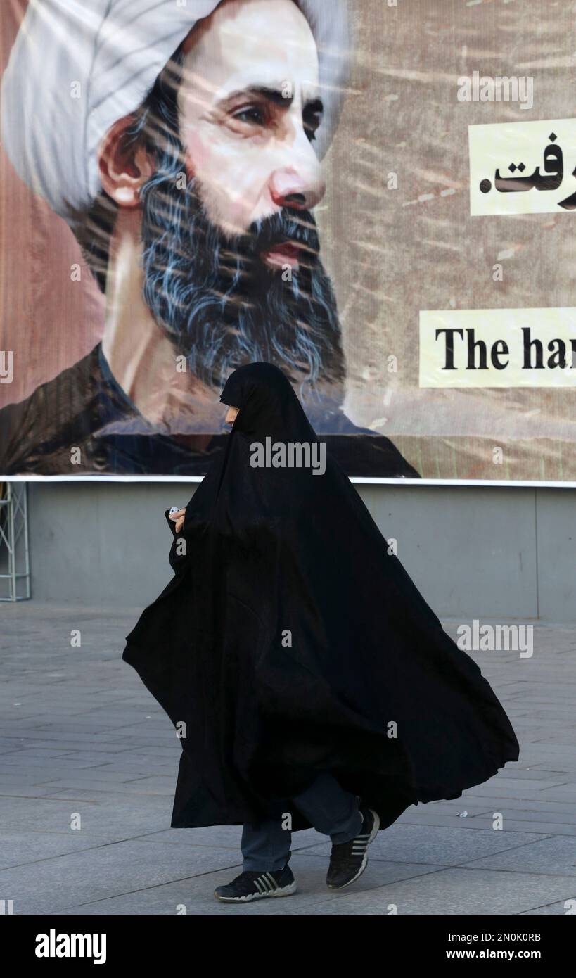 An Iranian woman walks past a portrait of Sheikh Nimr al-Nimr, a ...