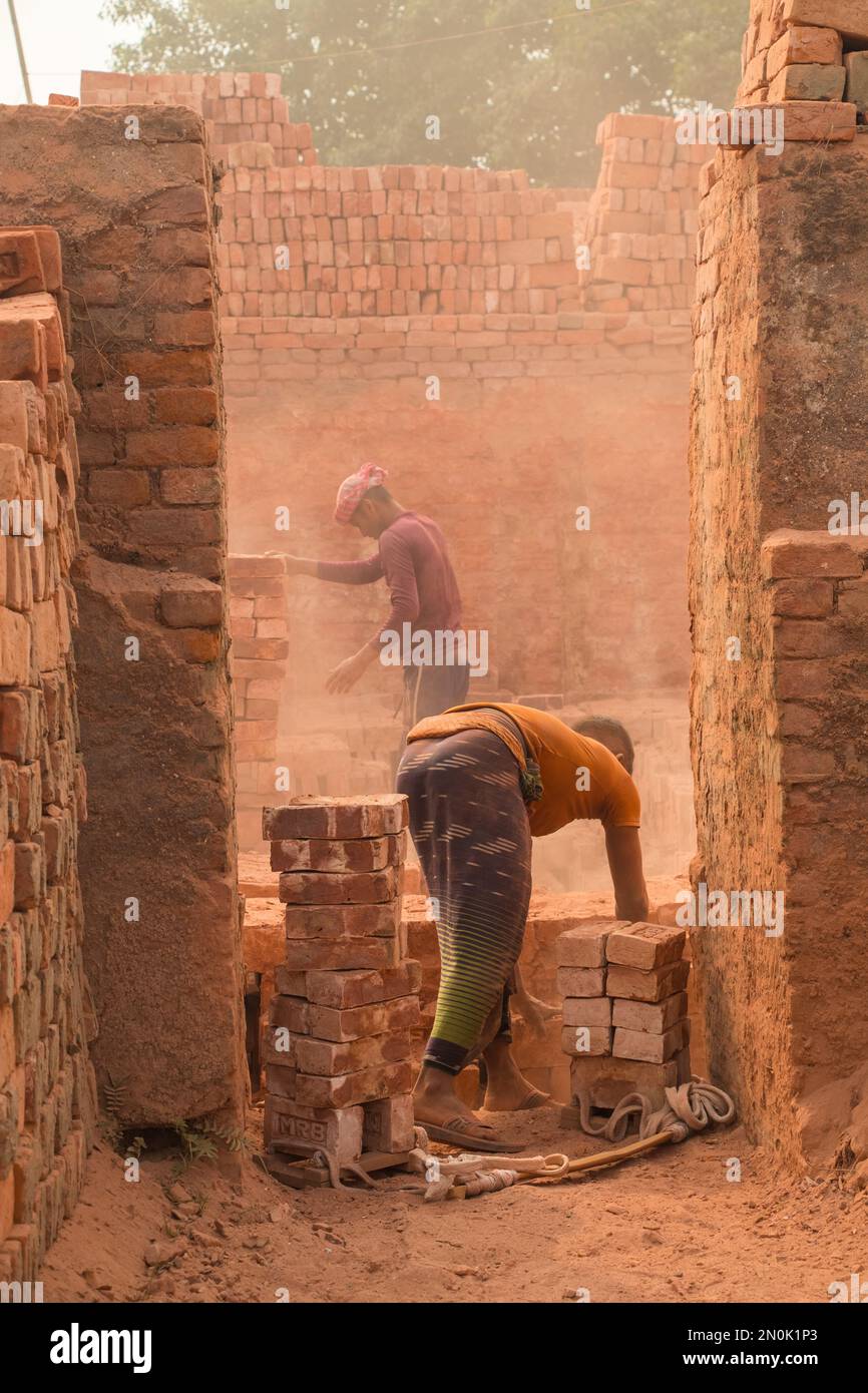 People are working hard in the brick field. This image was taken from ...