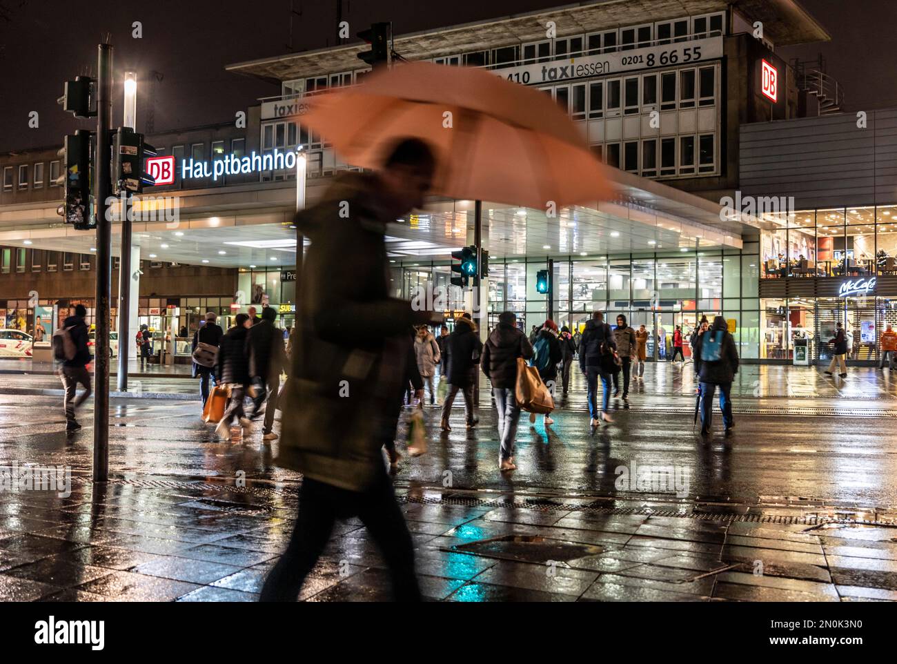 Passers-by at a pedestrian crossing, at the main station, rainy weather ...