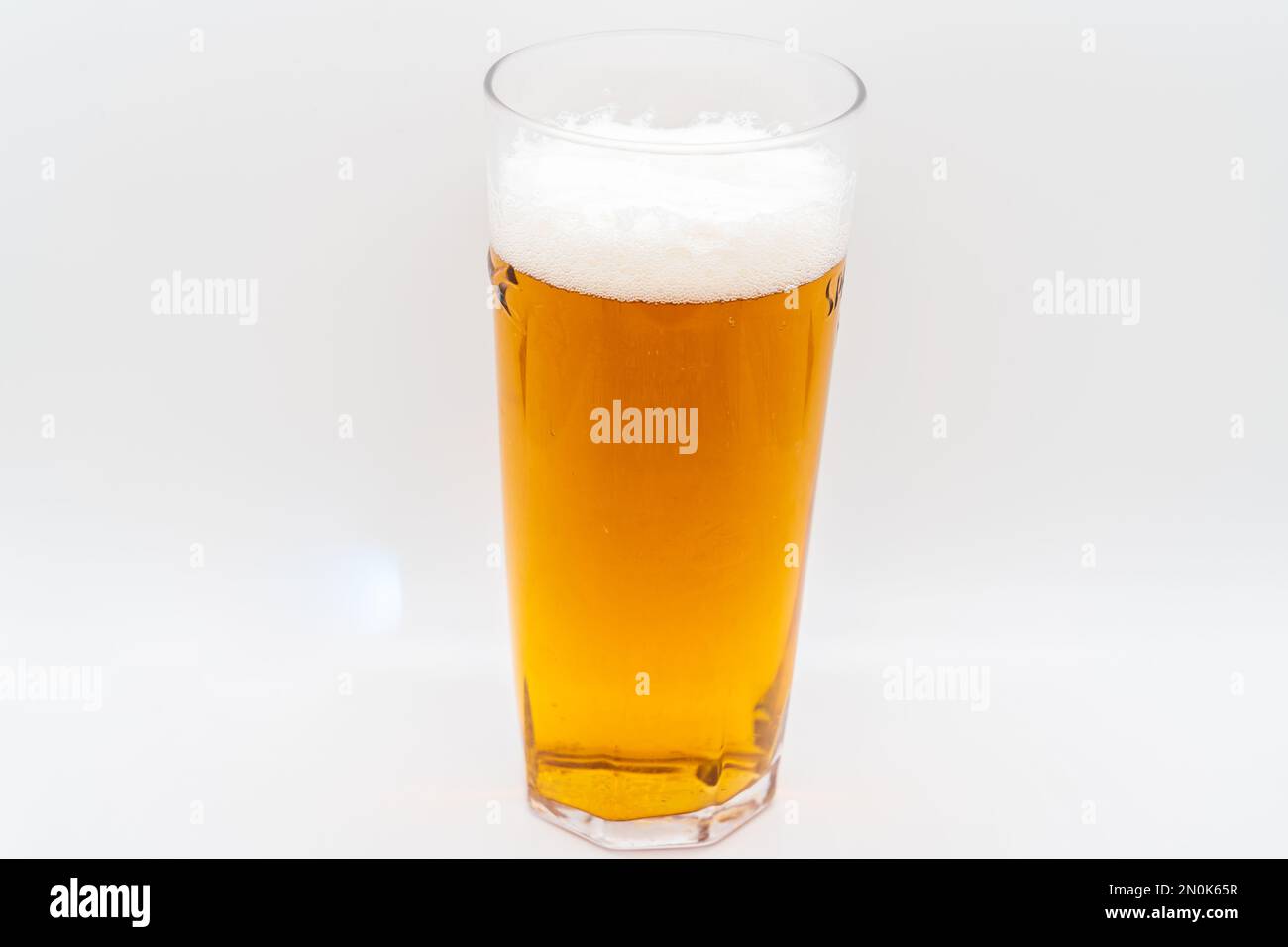 Pint of cold lager beer in a glass isolated on a whiite background ...