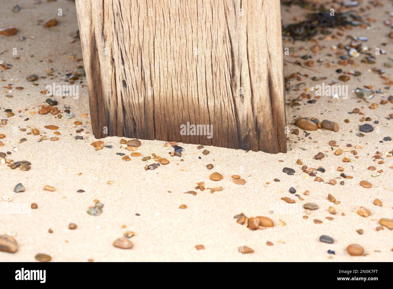 Wooden post embedded in sand Stock Photo - Alamy