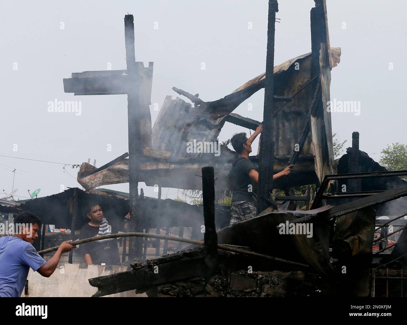 Residents sift through the debris following an early morning fire that ...