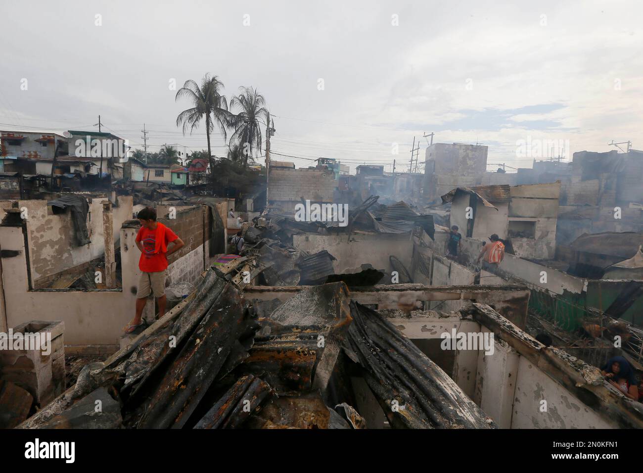 Residents sift through the debris following an early morning fire that ...