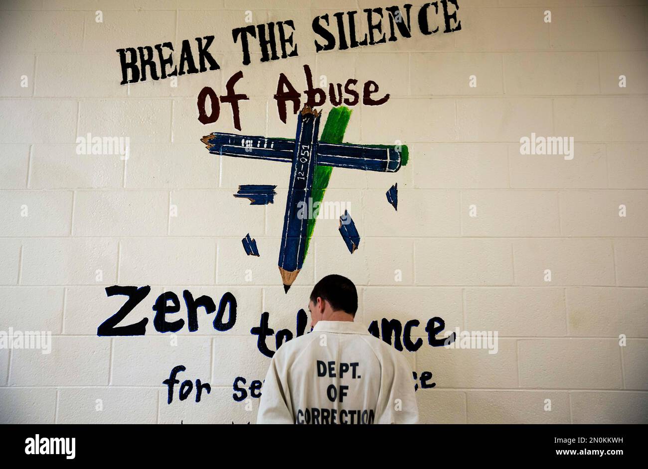A prisoner faces a mural painted by inmates on a cinderblock wall ...