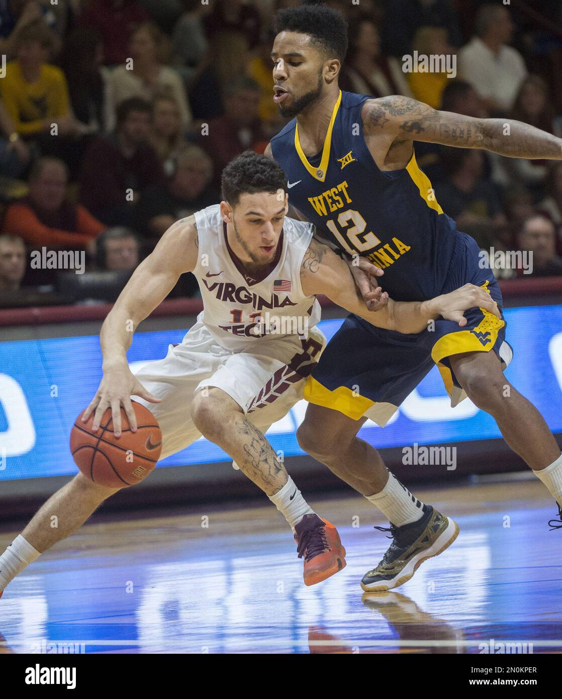 West Virginia's Tarik Phillip (12) guards Virginia Tech's Devin Devin Wilson (11) during the ...
