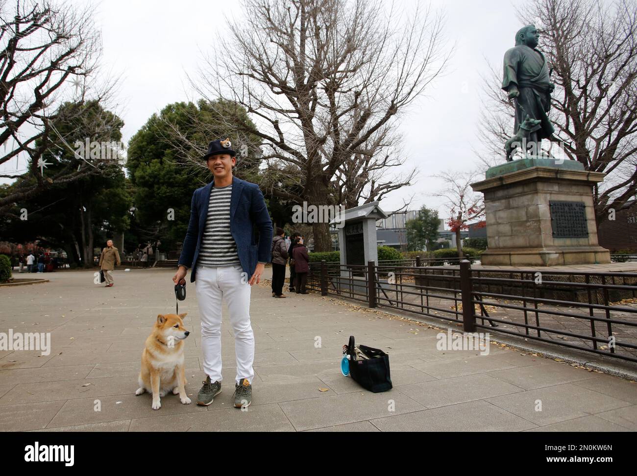 In this Wednesday, Dec. 23, 2015 photo, Shinjiro Ono stands with his Shiba Inu Maru in front of ...