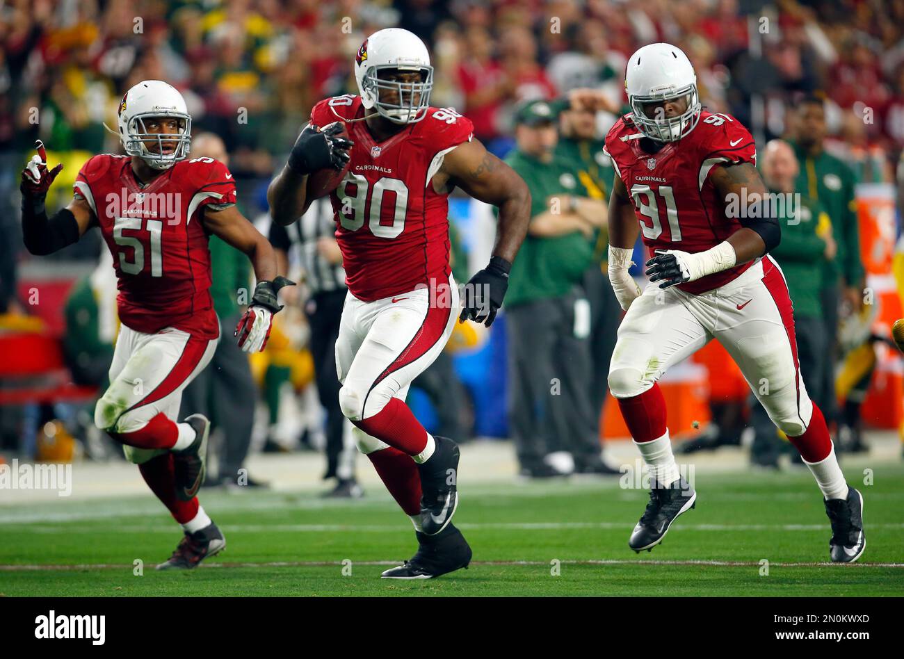 Arizona Cardinals defensive end Cory Redding (90) picks up a fumble and ...