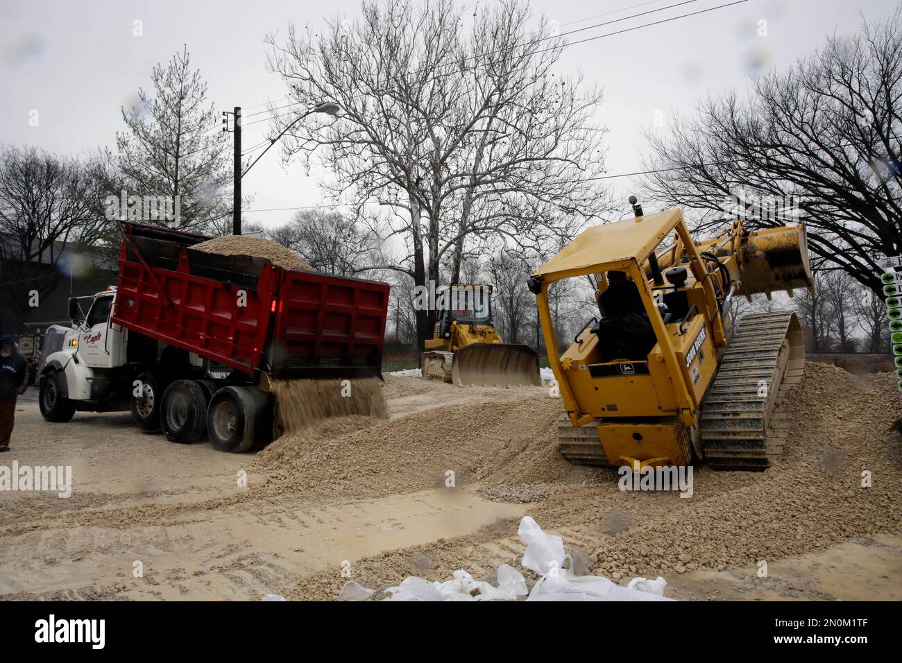 Heavy equipment is used to build a temporary levee to hold back ...
