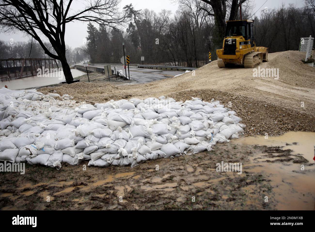 A bulldozer is used to build a temporary levee to hold back floodwater ...
