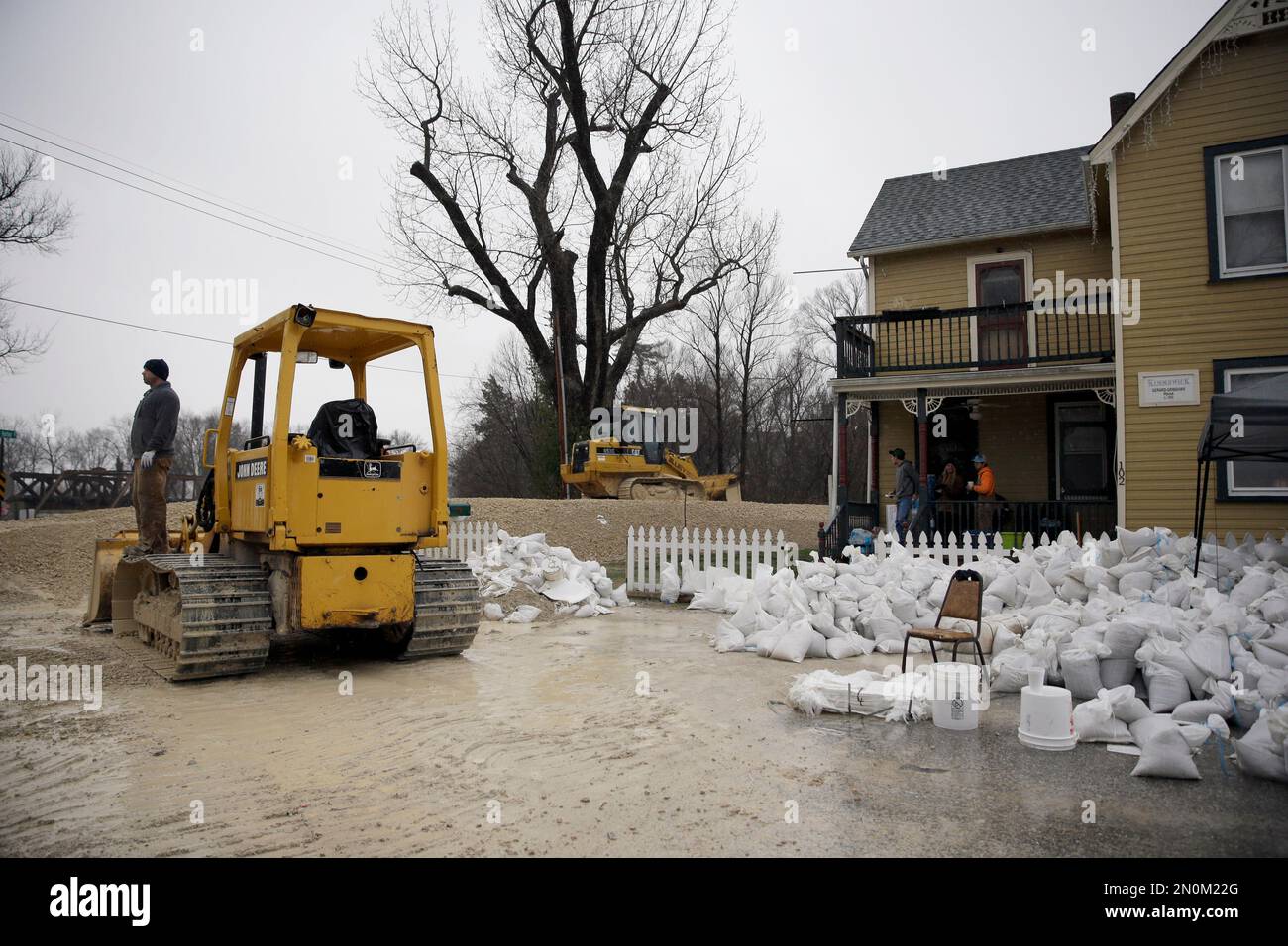 Heavy equipment is used to build a temporary levee to hold back ...