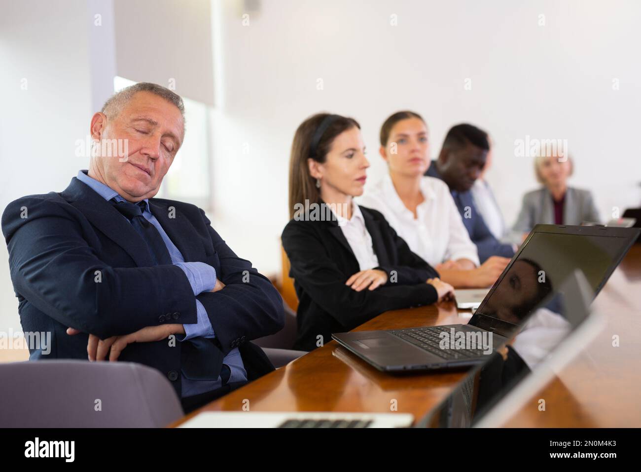 Mature businessman fell asleep at a business meeting in negotiation ...