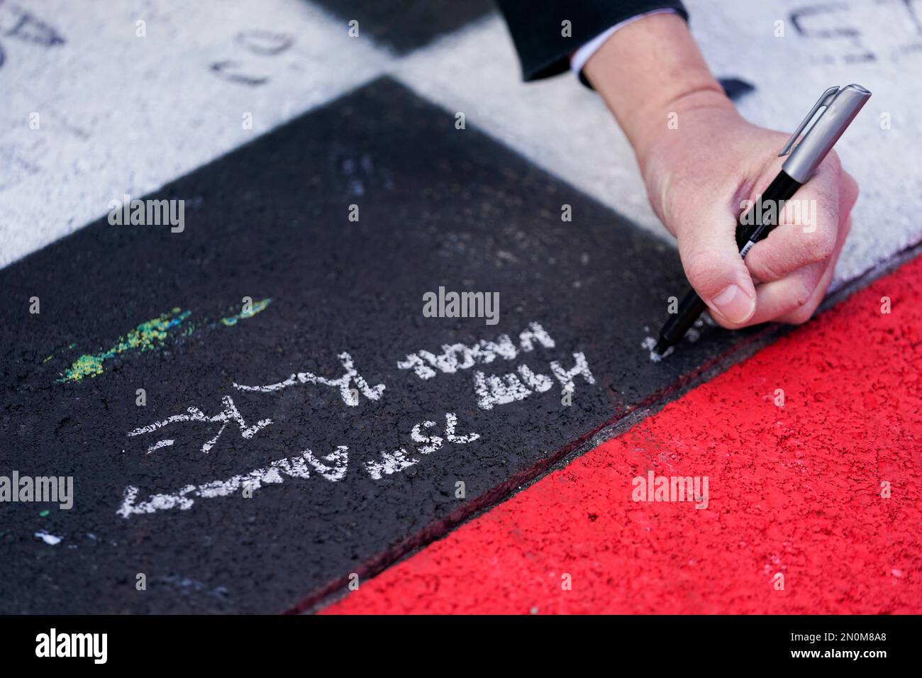 A fan signs the finish line ahead of a NASCAR exhibition auto race at ...