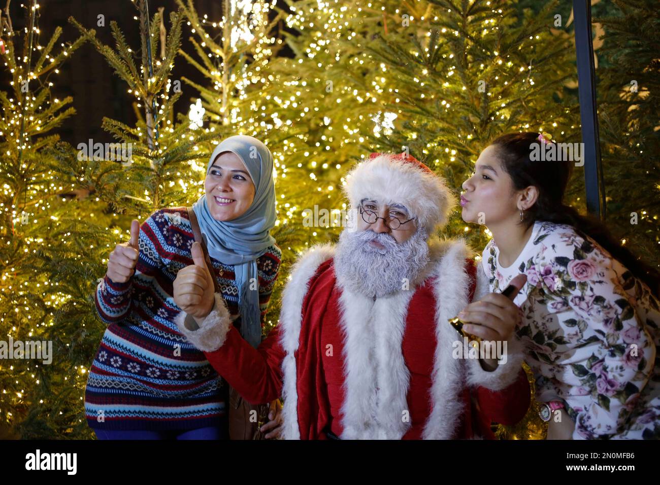 Lebanese Muslims pose for a photo with a man dressed as Santa Claus in ...