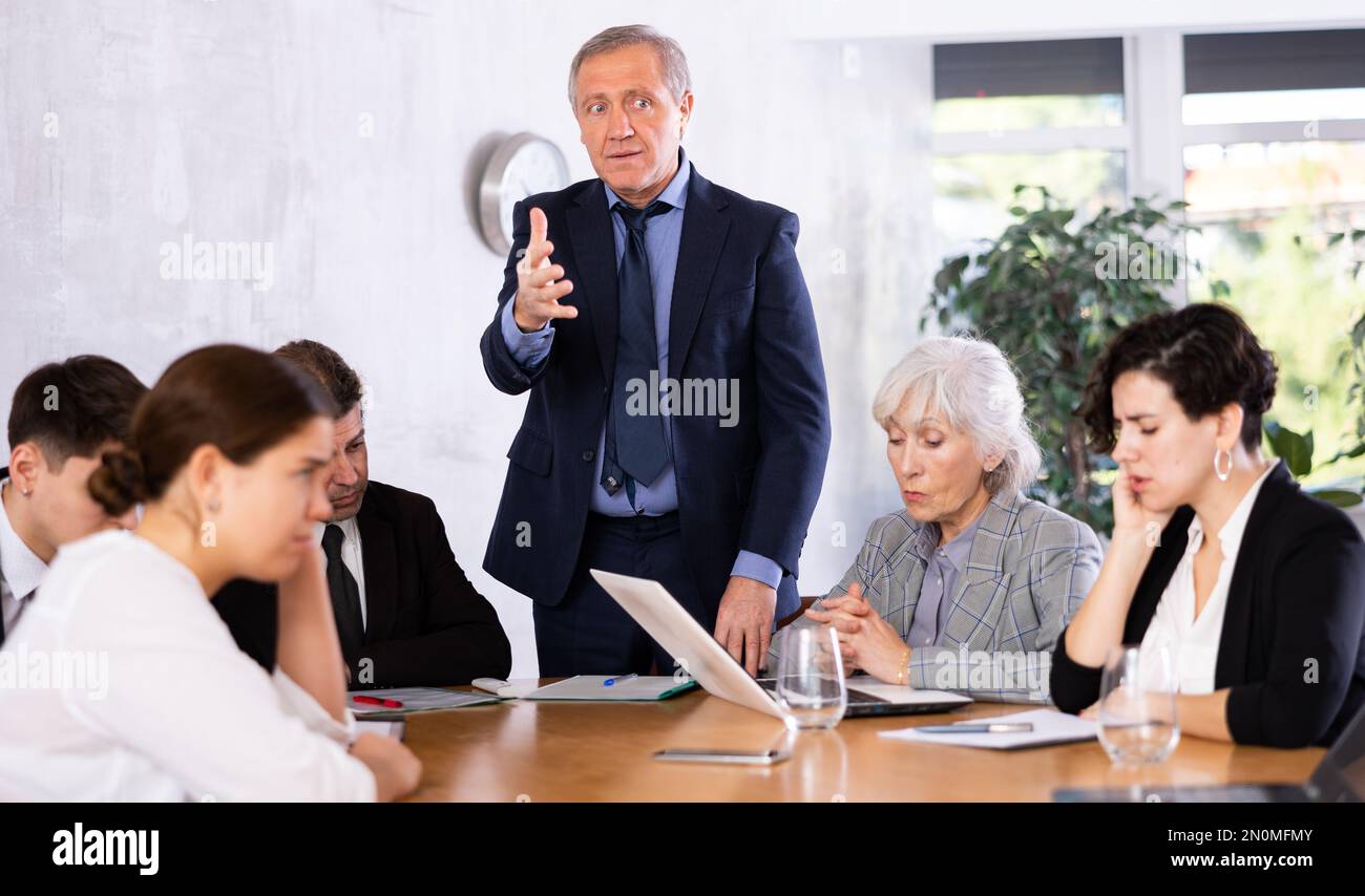 Portrait of angry male boss in business suit pointing to the door to ...