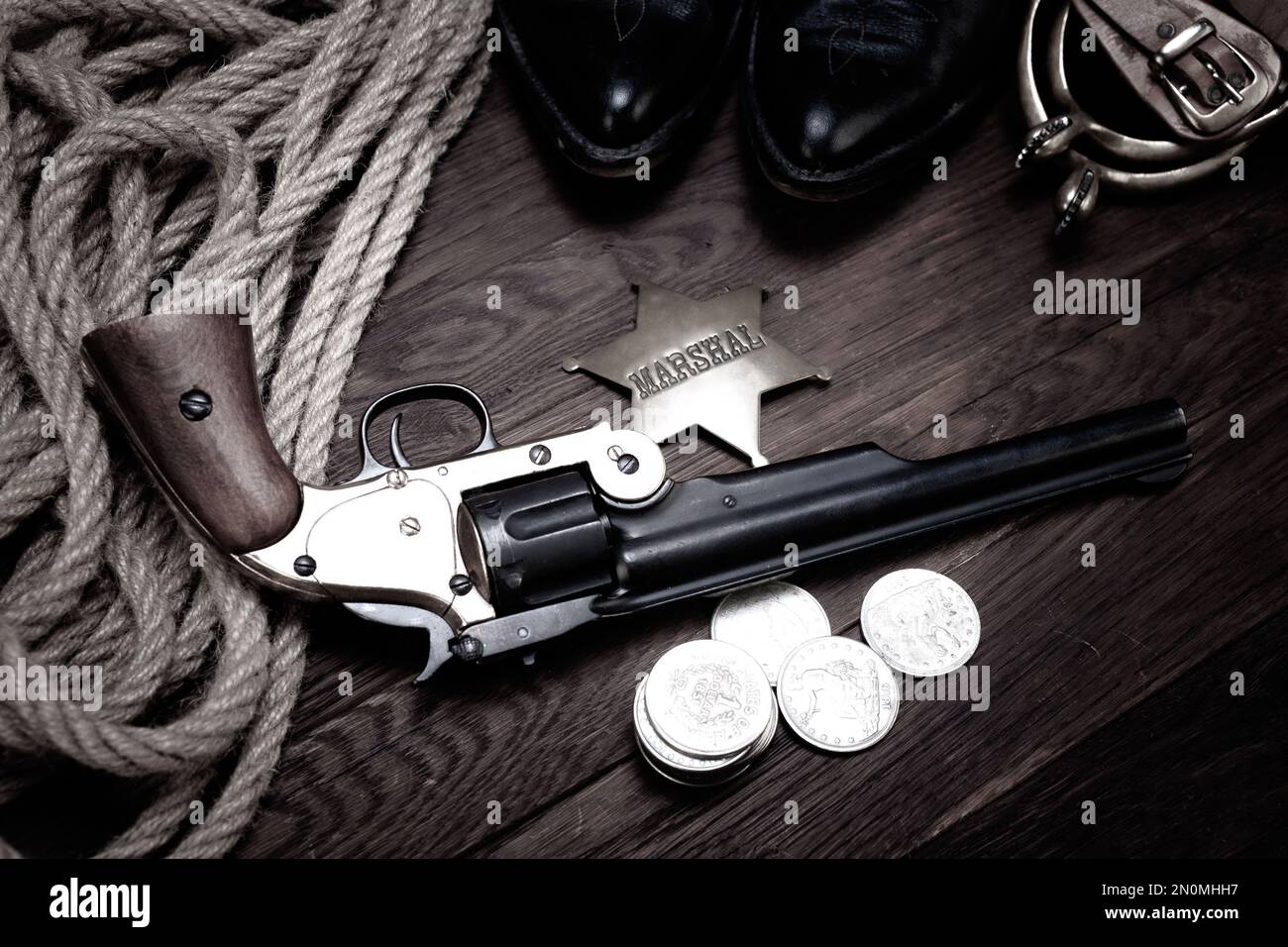 Old West revolver with U.S. Marshal badge and silver dollars with hat ...