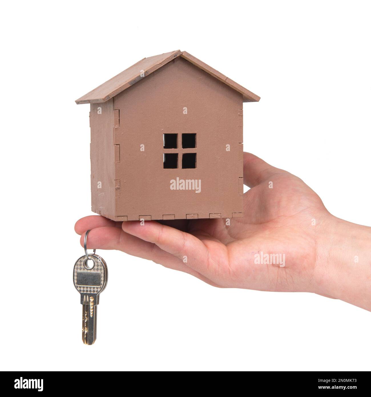 Hand holding keys and wooden house isolated on the white background ...
