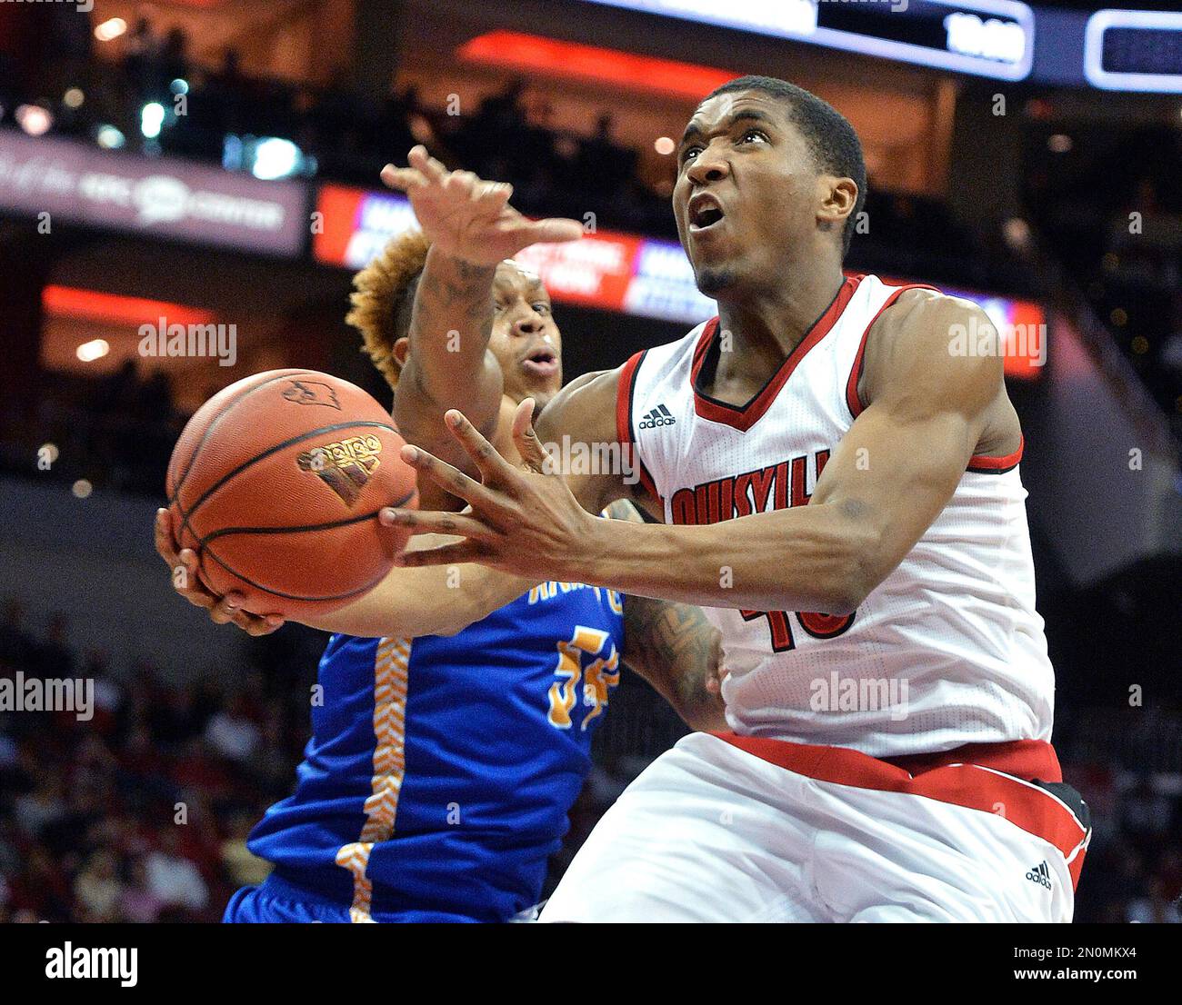 Louisville's Donovan Mitchell, right, goes to the basket past UMKC's ...