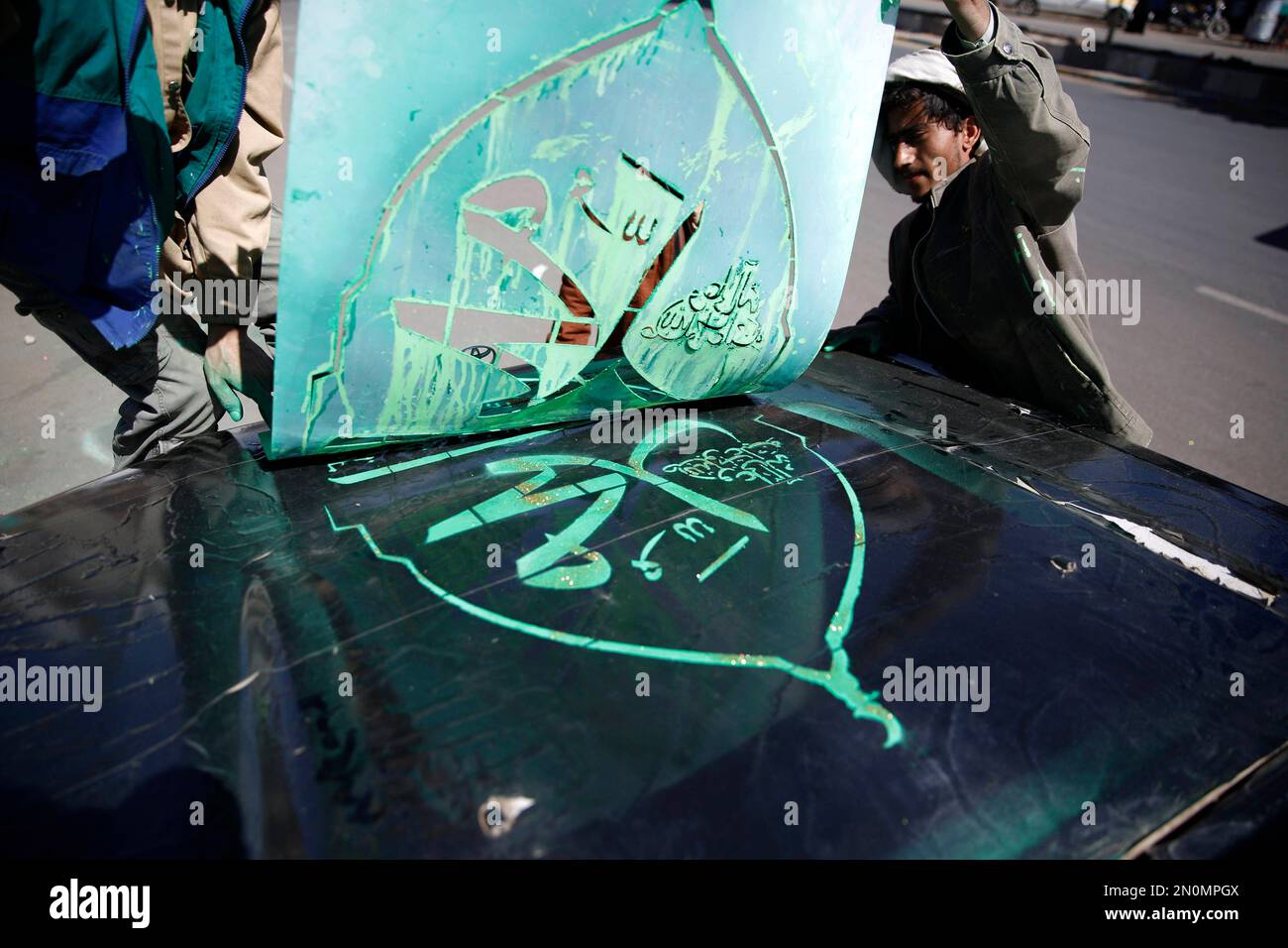 Men use a stencil bearing the name of the Prophet Muhammad in Arabic on ...