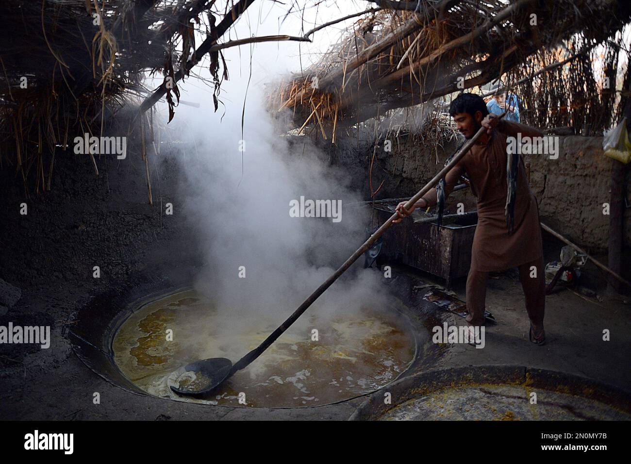 An Afghan laborer produces sugar cane juice in a traditional juice ...