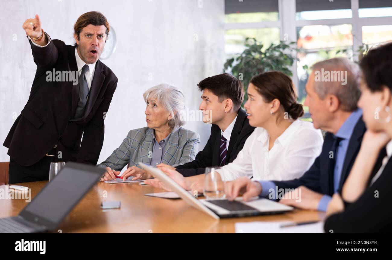 Angry boss scolding subordinates at meeting in office Stock Photo - Alamy