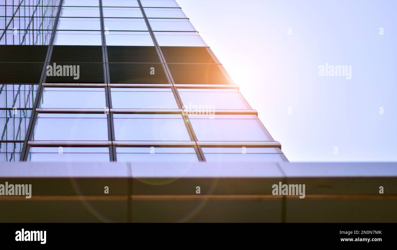 Bottom view of modern skyscrapers in business district against blue sky ...