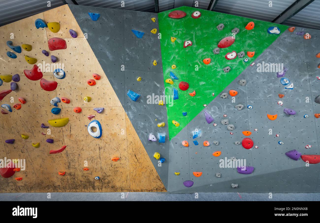 Large indoor traverse climbing wall with many coloured holds and grips ...