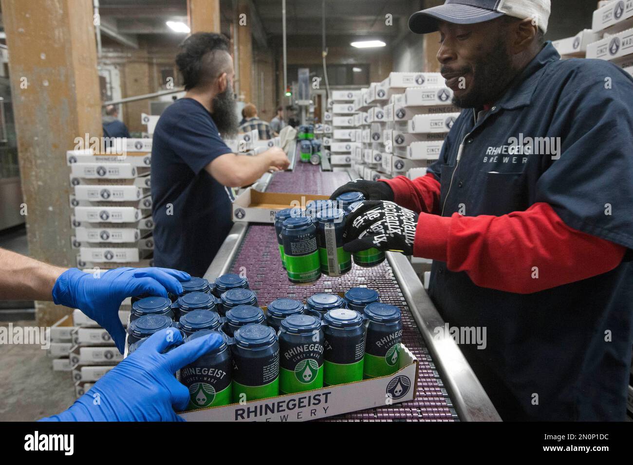 Packaging worker Rob Gunn, right, loads cases with six-packs of beer as ...