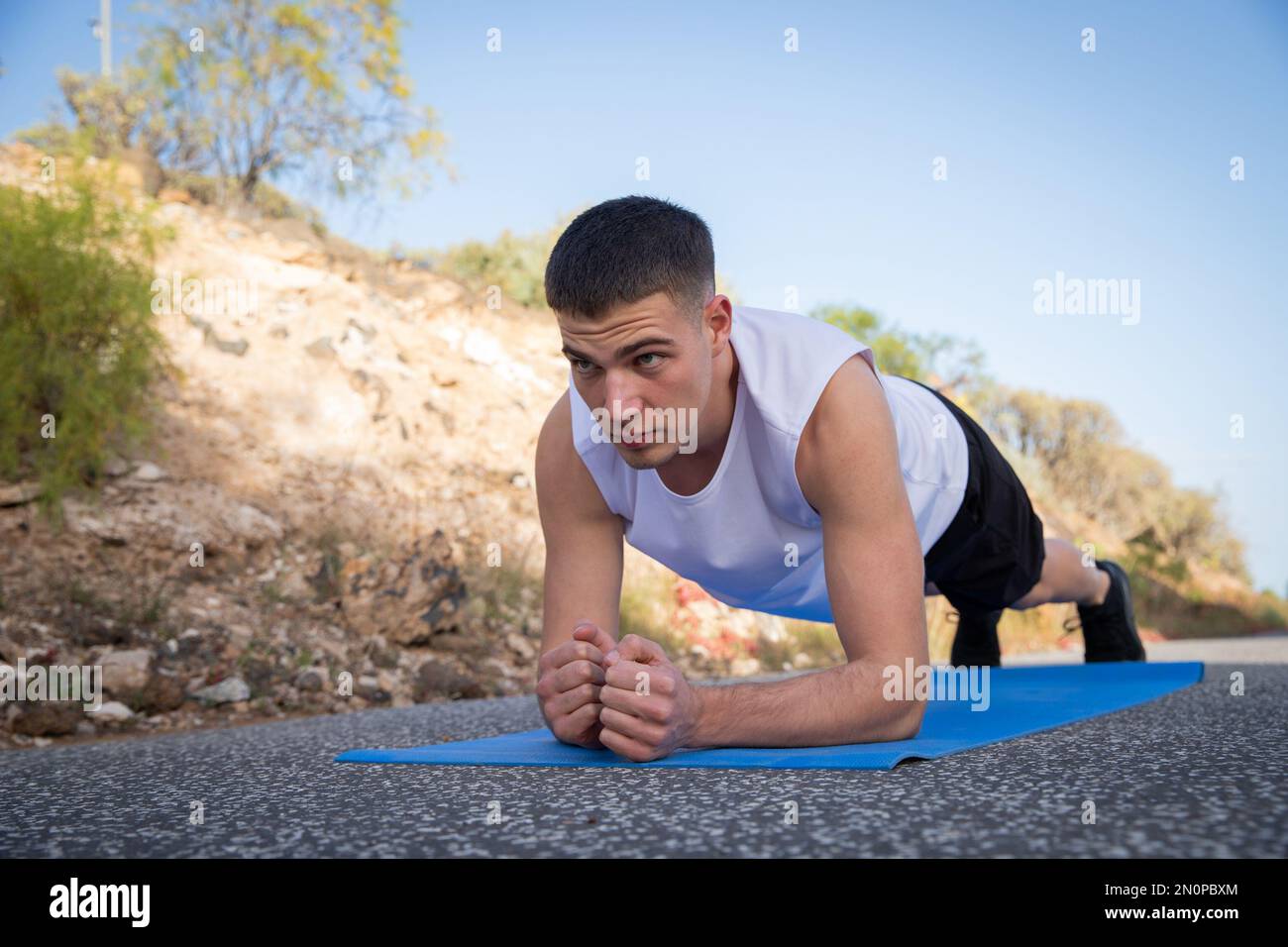 A young athlete performs a plank exercise during a workout, photo with ...