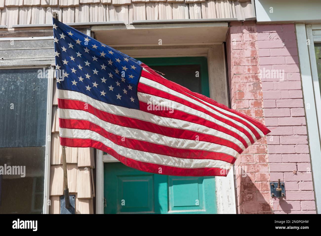 American flag in front of a building, a shop window on main street ...