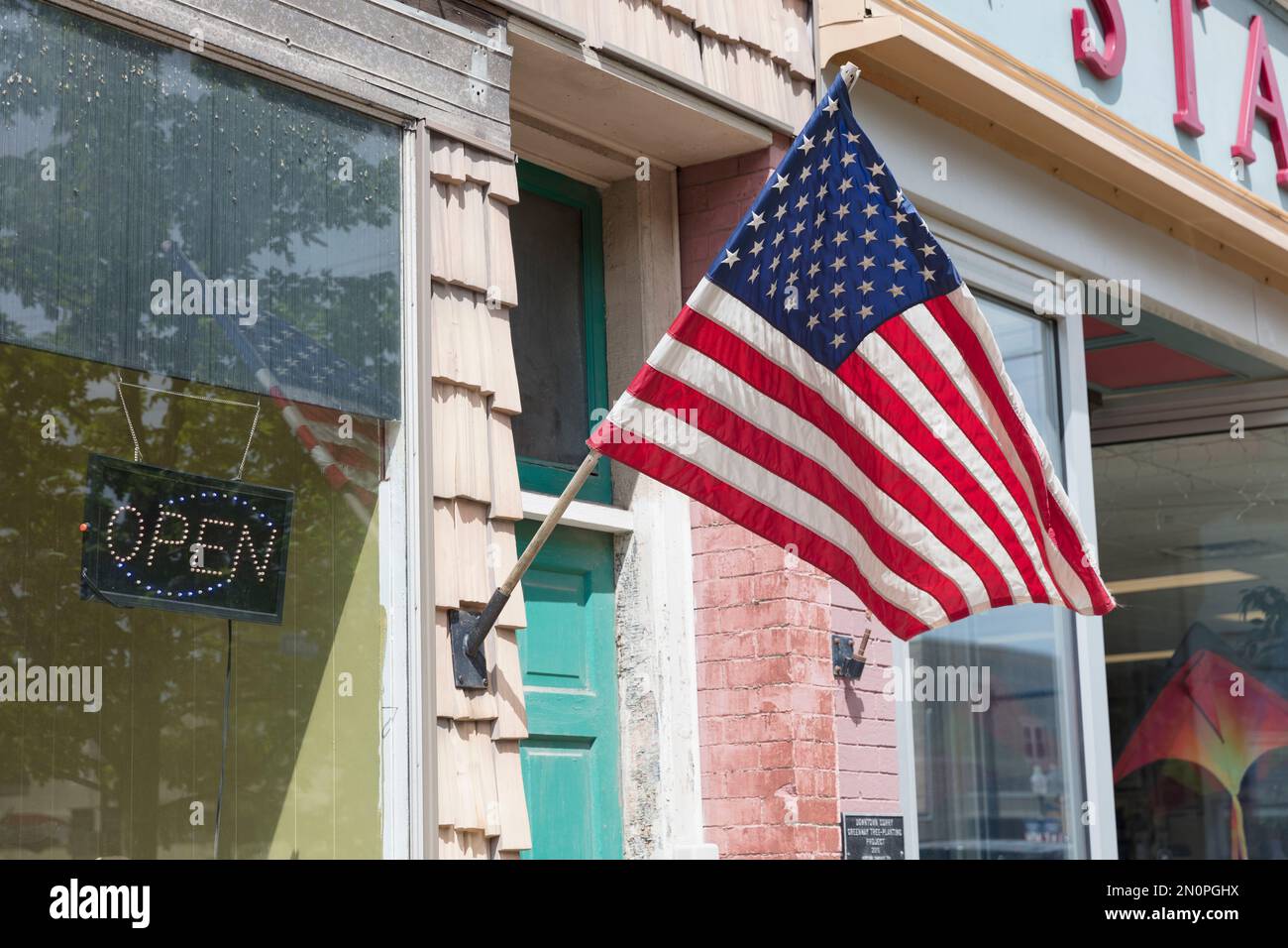 American flag in front of a building, a shop window on main street ...