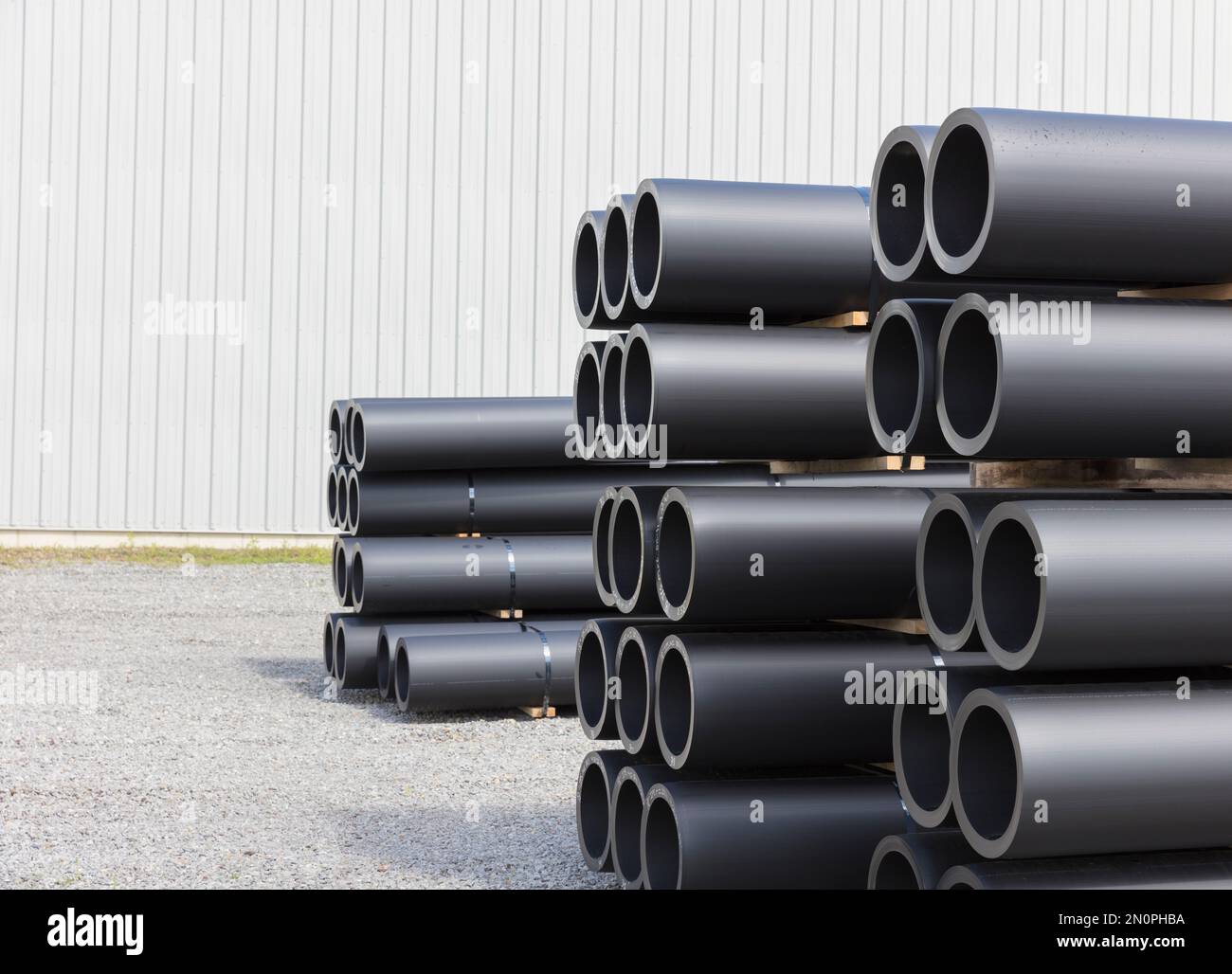 Stacks of industrial PVC pipes piled up outside a manufacturing ...