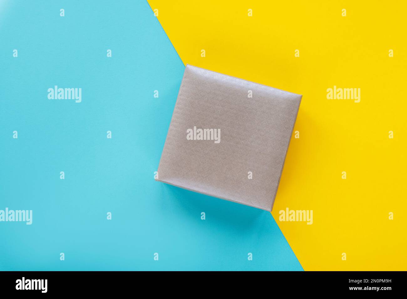 Gray box on yellow and blue background. Top view, flat lay, mockup ...