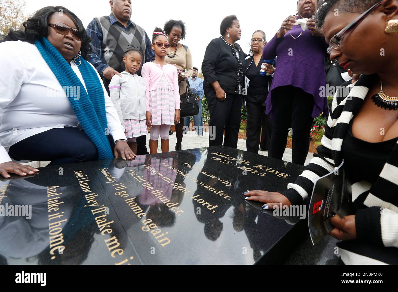 Family members touch the black granite during the unveiling of a black ...