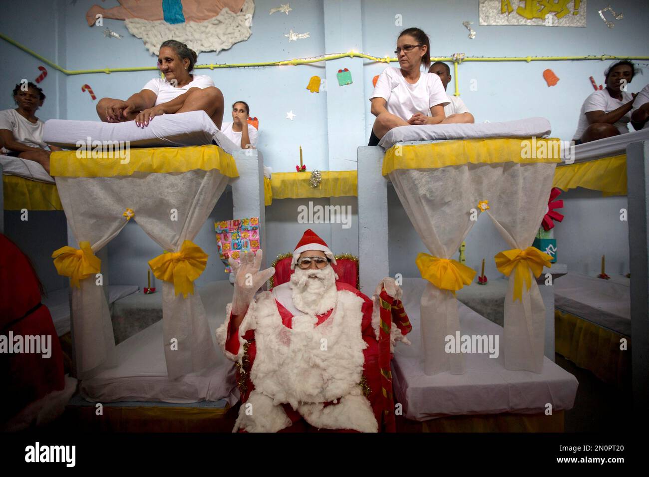 A prisoner dressed as Santa Claus sits on a bed during a Christmas ...